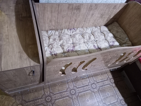 Детская кроватка с шкафчиком, двумя раздвижными ящиками и матрасом.