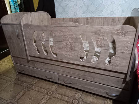 Детская кроватка с шкафчиком, двумя раздвижными ящиками и матрасом.