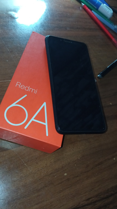 Redmi 6A, qora rangda, ustida zashitasi va chexoli bilan