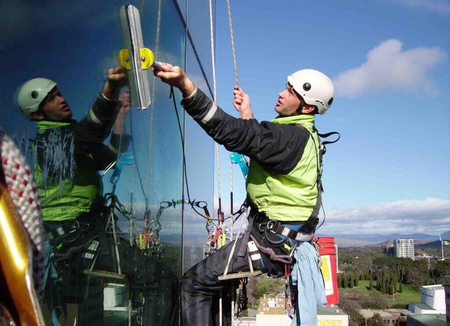 Alpinist baland binolar fasad oynalar yuvib beramiz